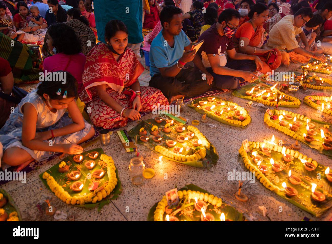Hindu devotees sit with Prodip (lights) and pray to God for the welfare ...