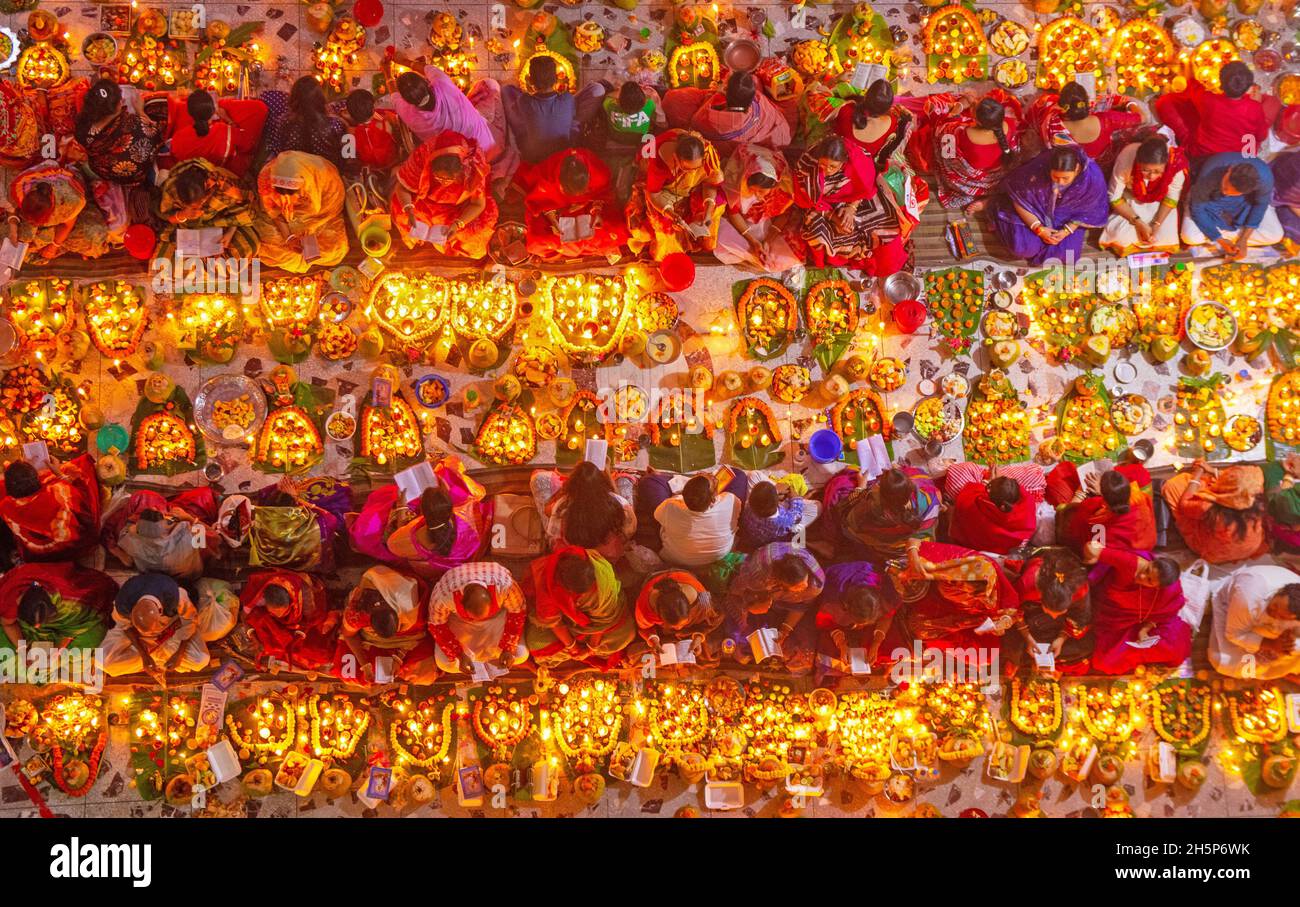 Hindu devotees sit with Prodip (lights) and pray to God for the welfare ...