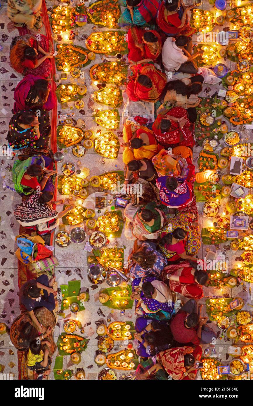 Hindu devotees sit with Prodip (lights) and pray to God for the welfare ...