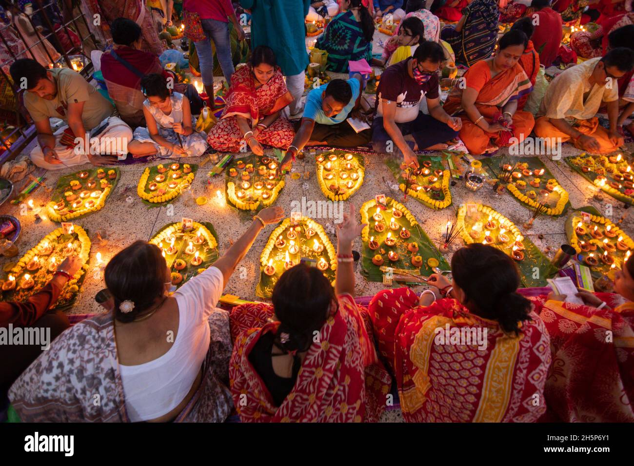 Hindu devotees sit with Prodip (lights) and pray to God for the welfare ...