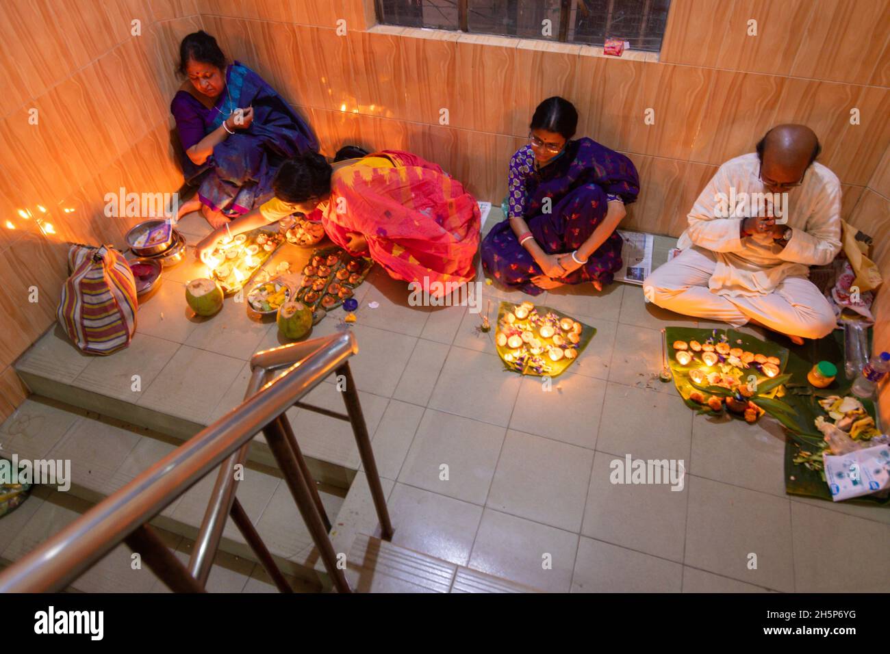 Hindu devotees sit with Prodip (lights) and pray to God for the welfare ...