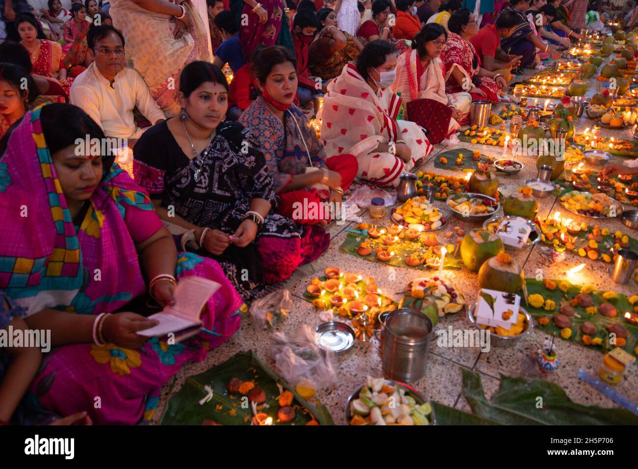 Hindu devotees sit with Prodip (lights) and pray to God for the welfare ...