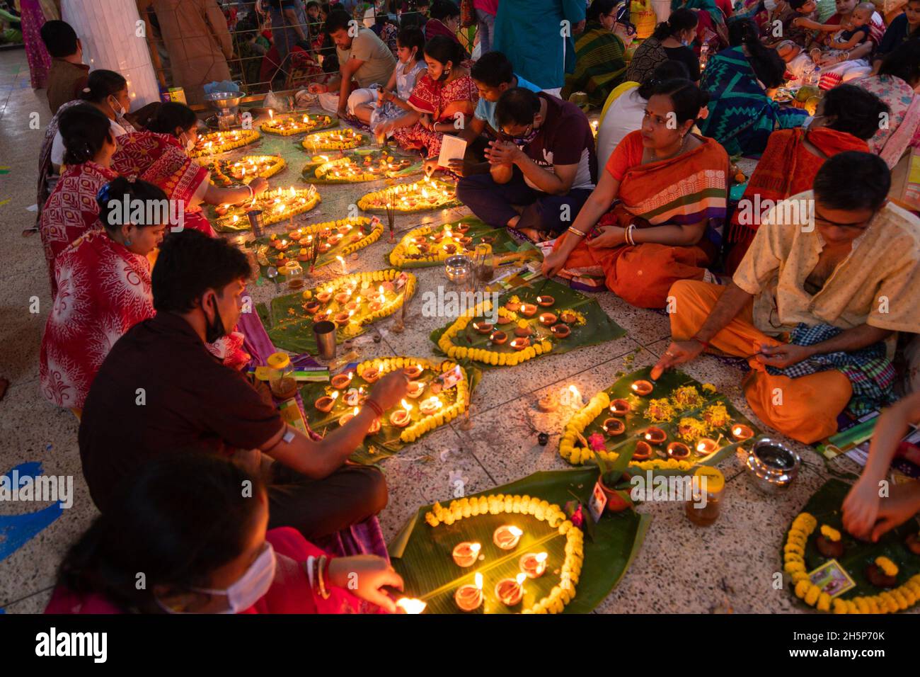 Hindu devotees sit with Prodip (lights) and pray to God for the welfare ...