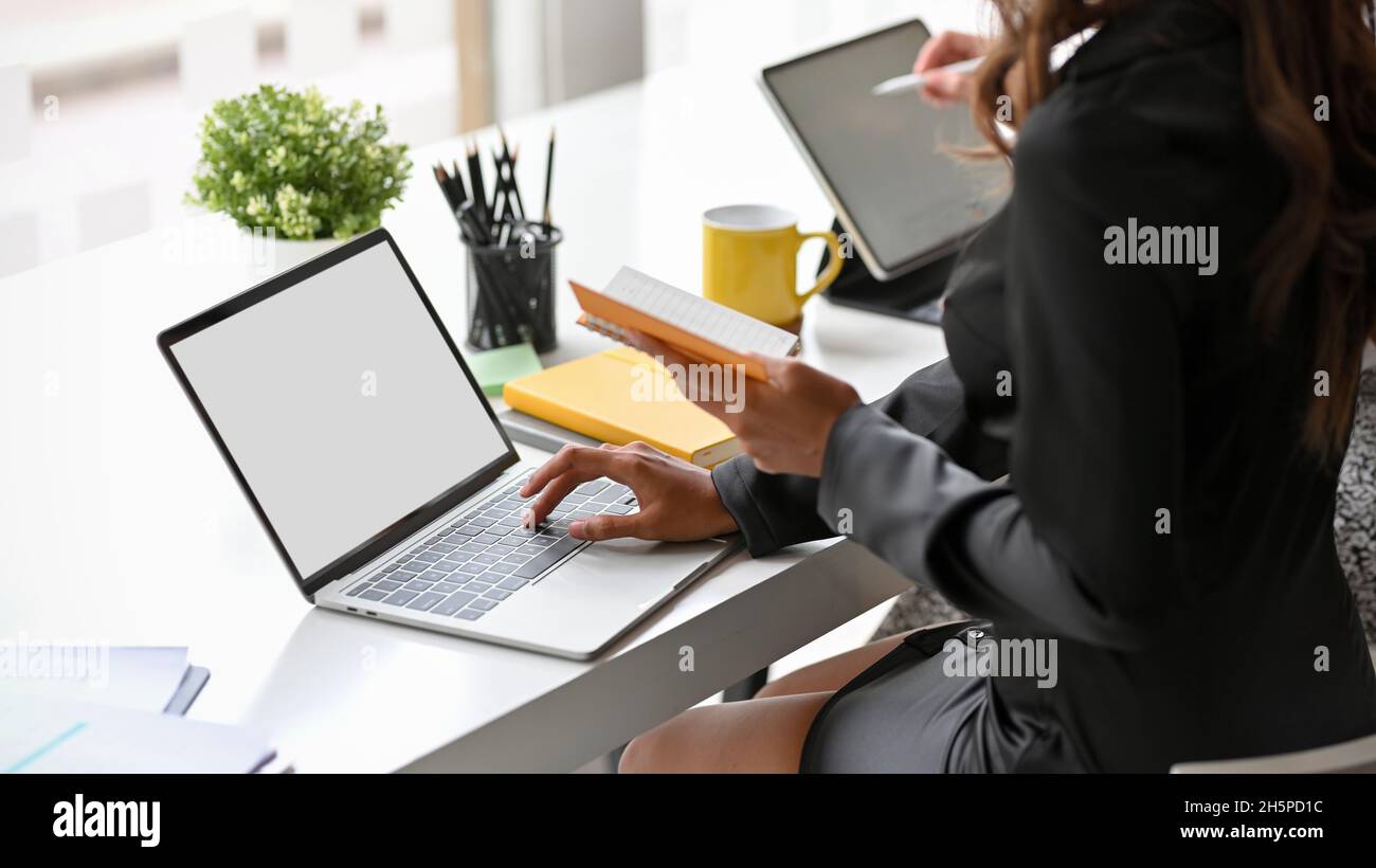 Cropped of elegant secretary working on laptop computer and checking ...
