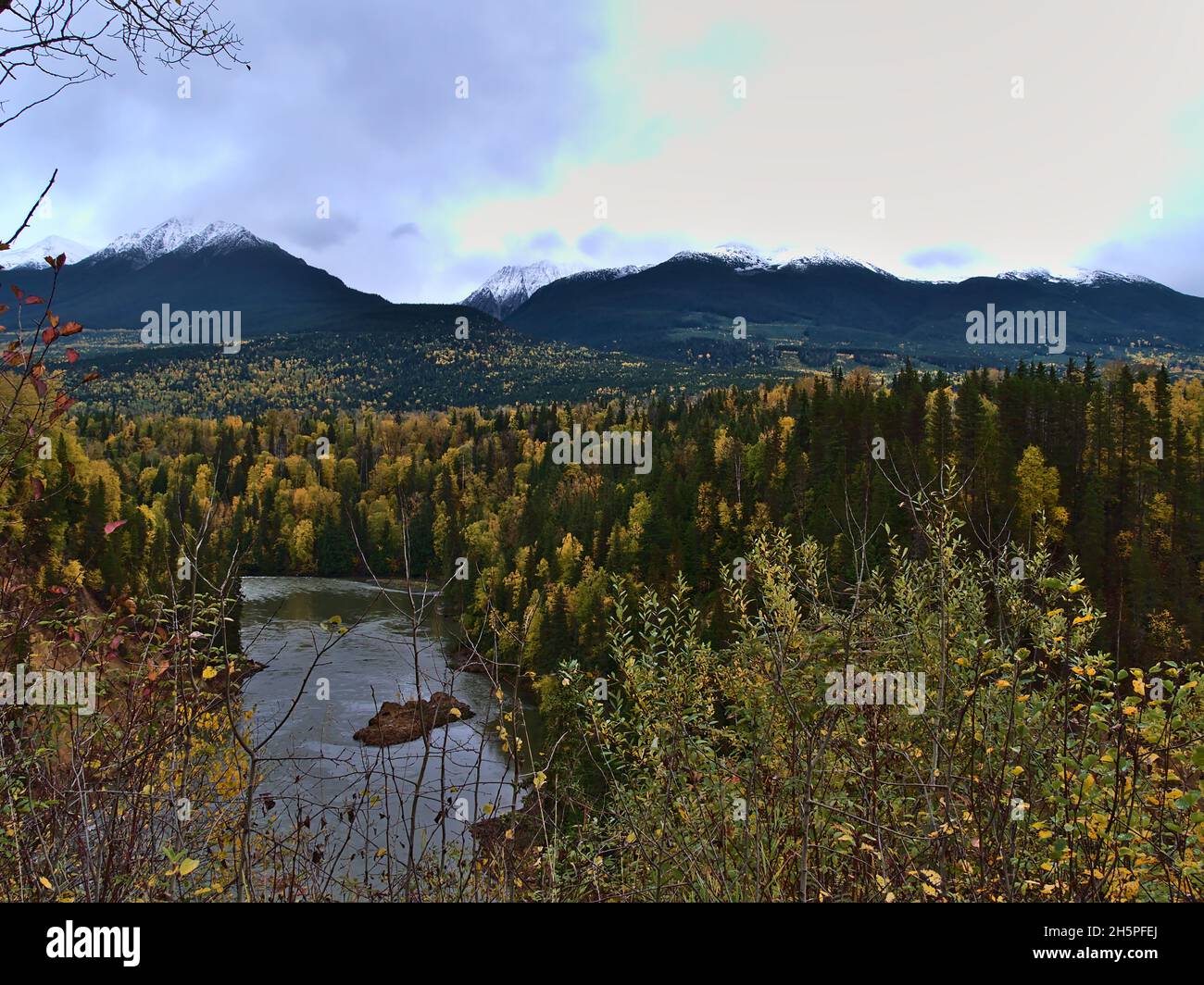 Landscape with Bulkley River in valley surrounded by colorful trees in ...