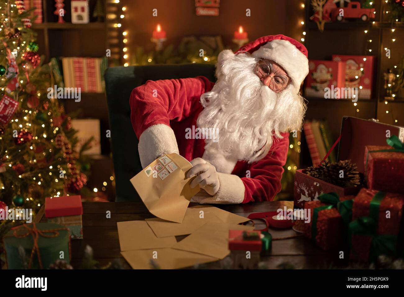 Santa Clause is prepares presents for children for Xmas at his desk at ...