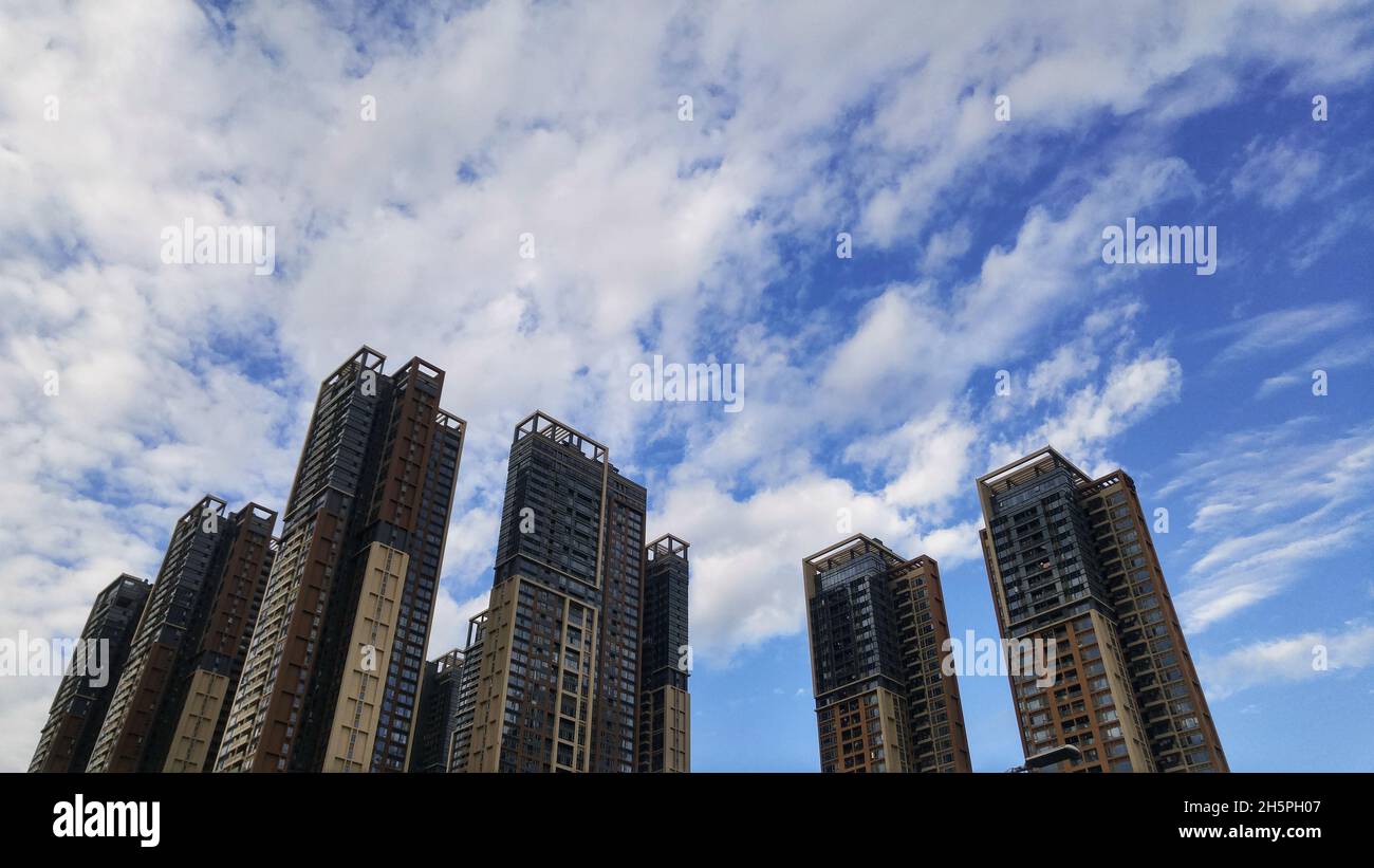 Residential buildings under blue sky and white clouds Stock Photo - Alamy