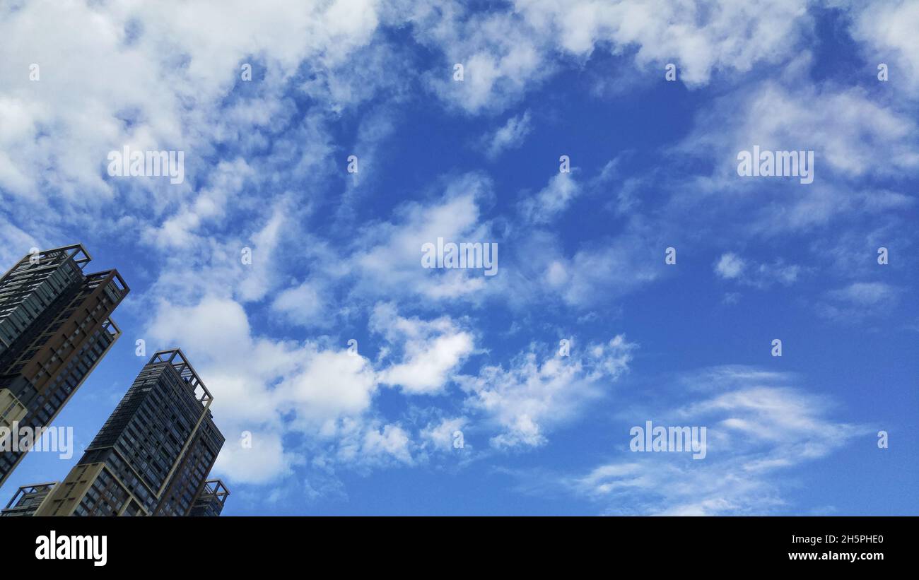 Residential buildings under blue sky and white clouds Stock Photo - Alamy