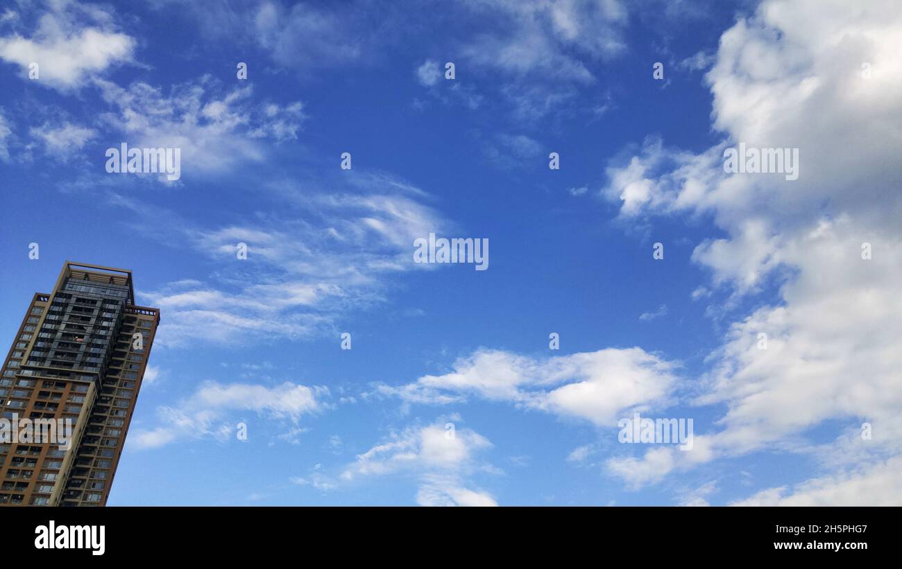 Residential buildings under blue sky and white clouds Stock Photo - Alamy