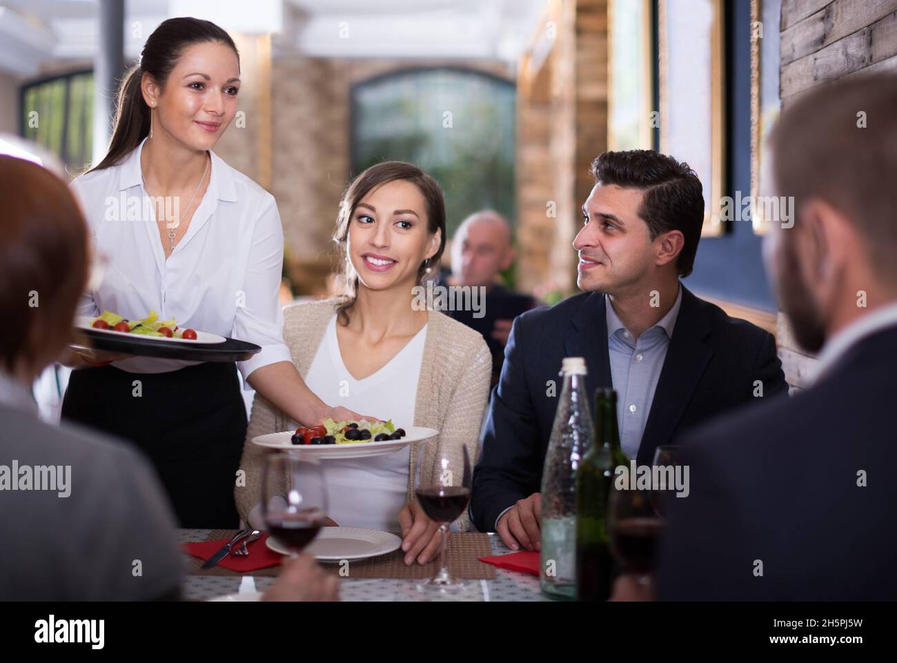 Positive waitress serving meal hi-res stock photography and images - Alamy