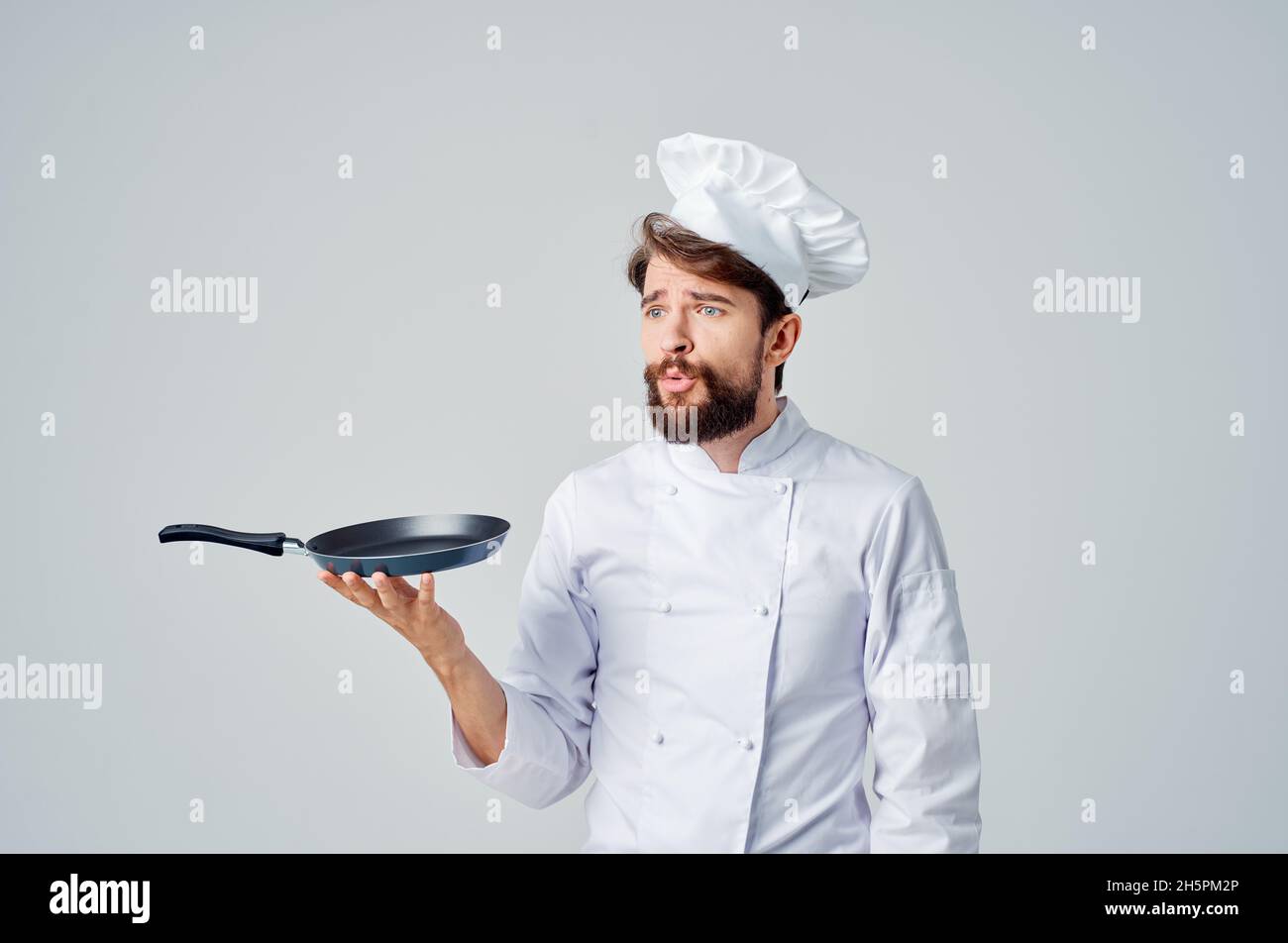 a man in a chef's uniform pan cooking kitchen Professional Stock Photo ...