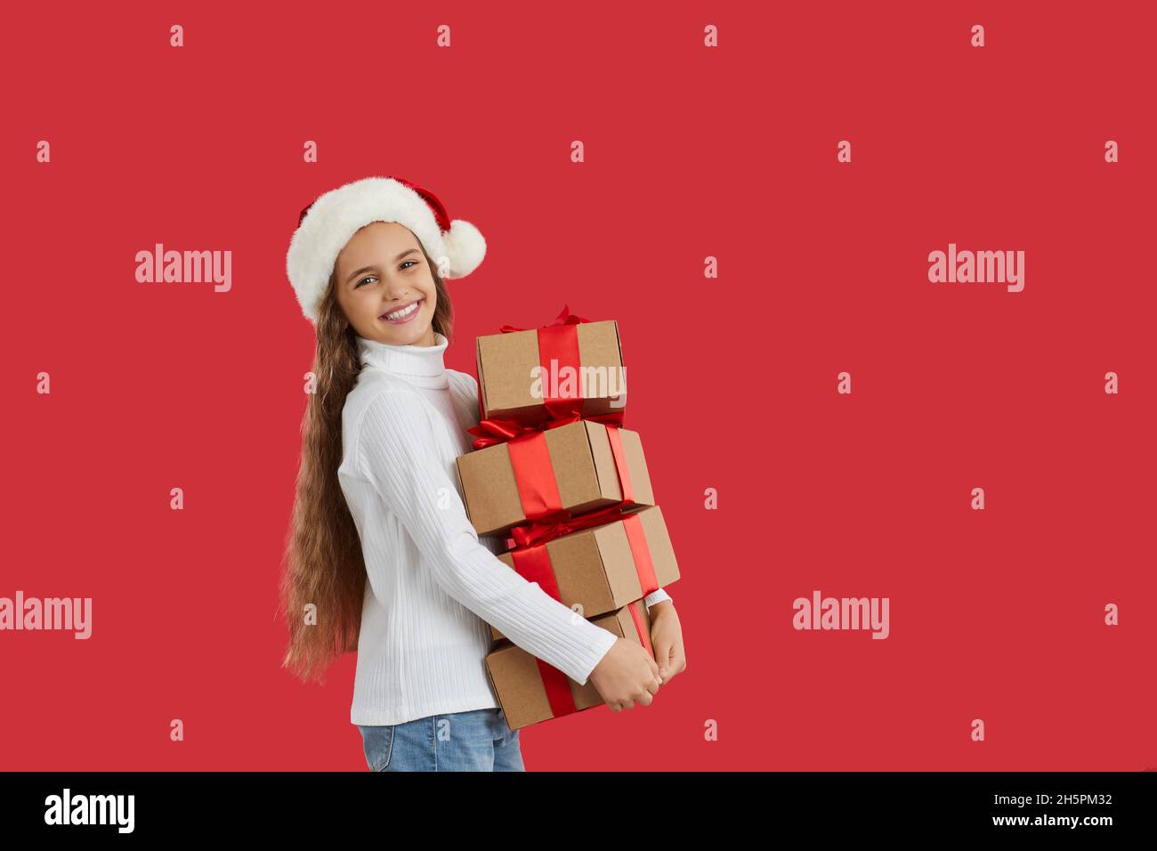 Portrait of happy child carrying stack of Christmas presents isolated ...