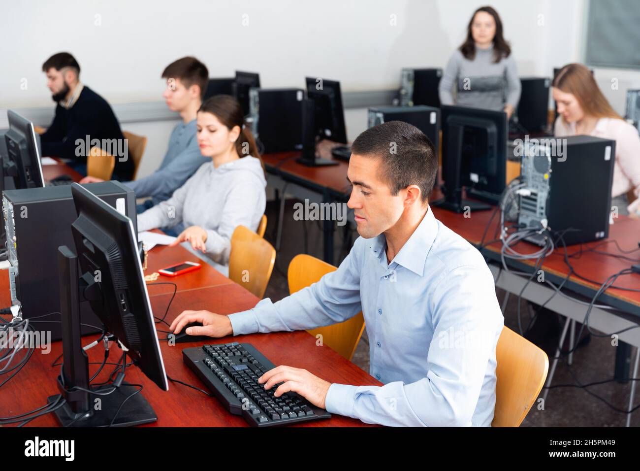 Computer lessons for adults in classroom Stock Photo - Alamy