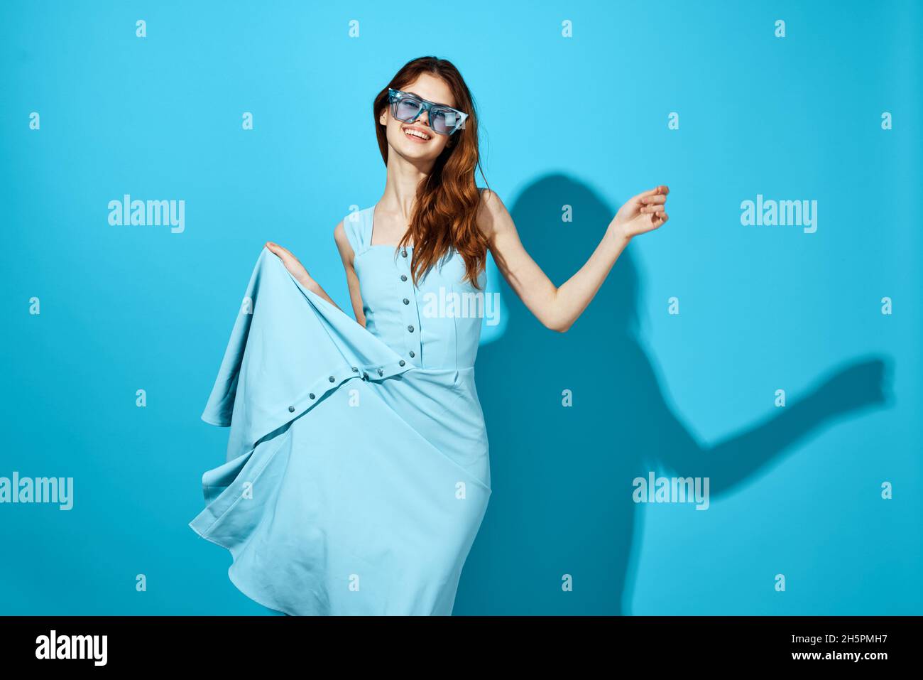 pretty woman in a blue dress blue background Lifestyle Stock Photo - Alamy