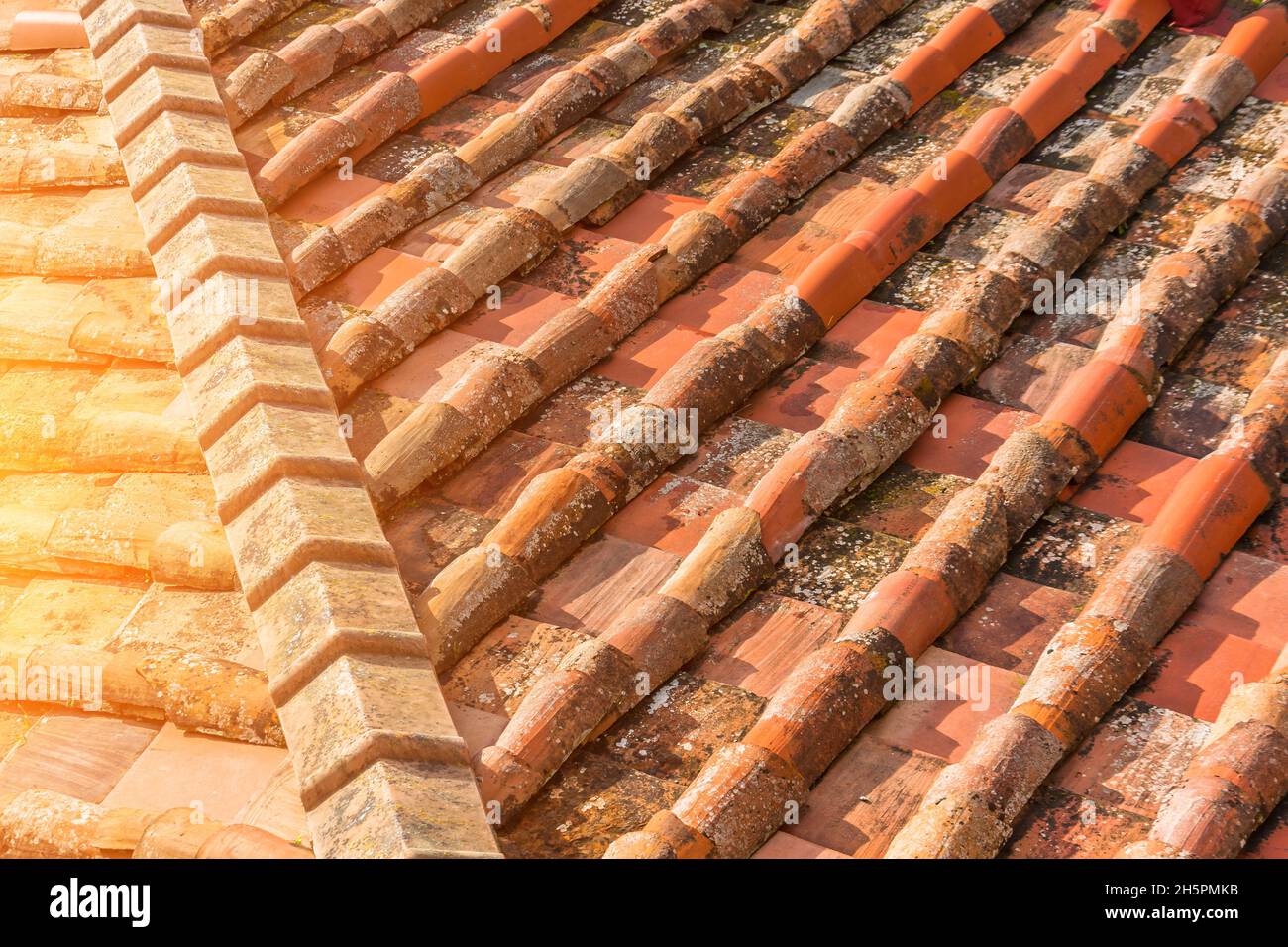 Ceramic orange clay tiles on the roof of a building, corner sunlight ...