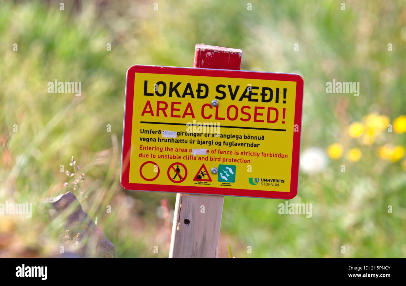 Yellow colored warning sign at the Latrabjarg, Iceland Stock Photo - Alamy