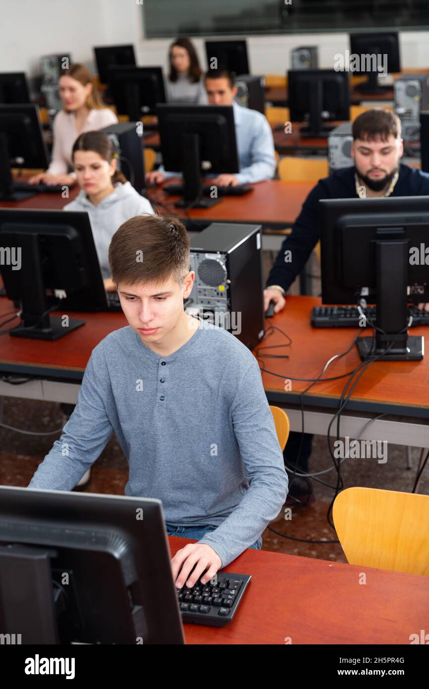 Group of people of different ages learning to use computers in ...