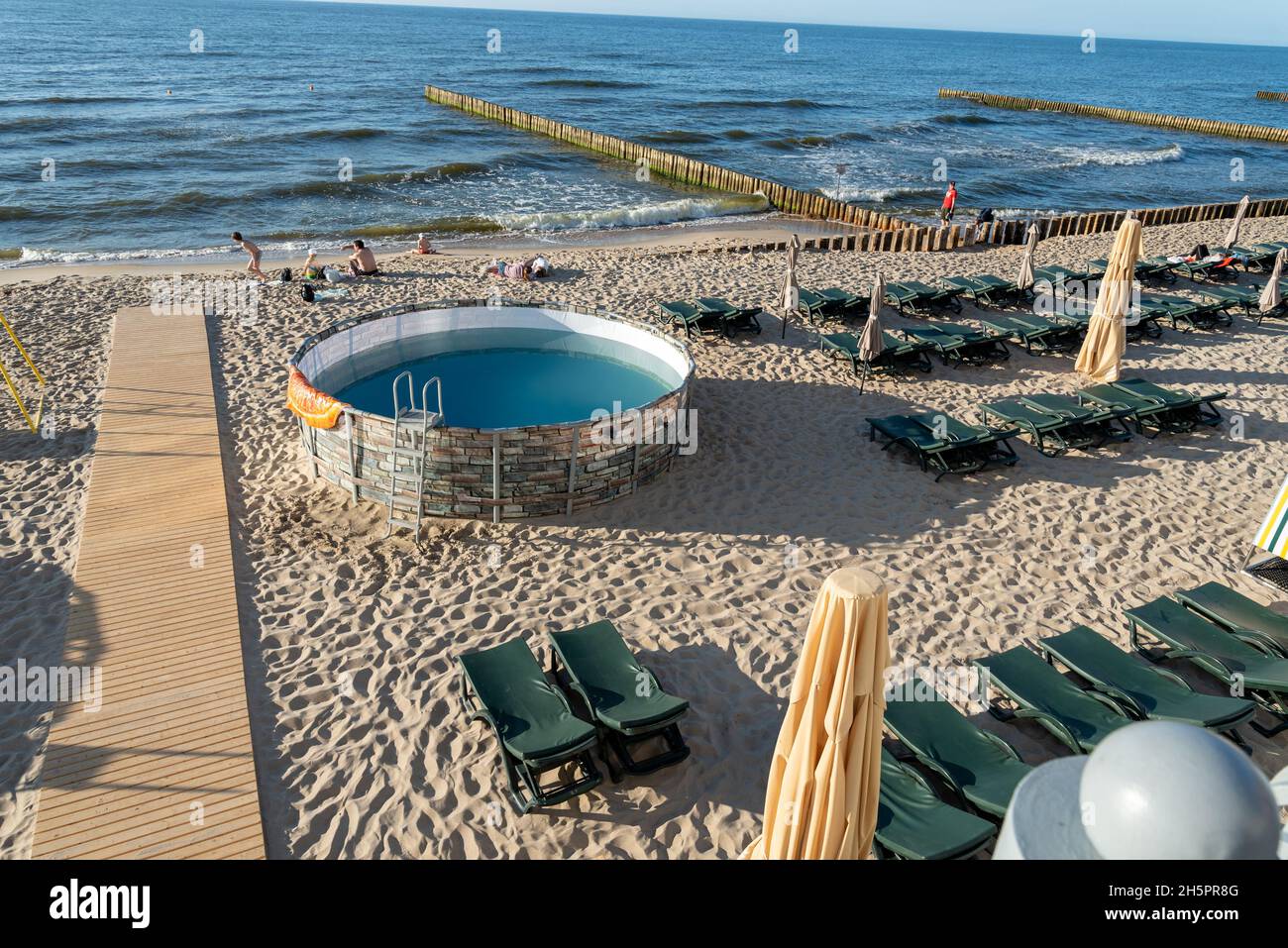 Round pool near the sea, on the beach for vacationers. The concept of ...