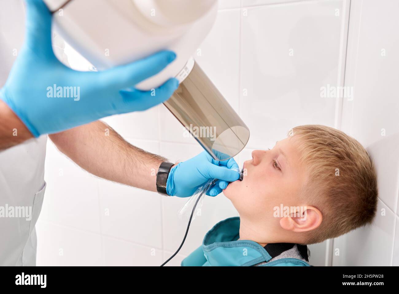 Radiographer taking teeth radiography to a boy using digital x-ray ...