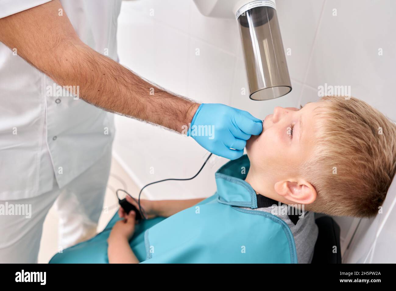 Radiographer taking teeth radiography to a boy using digital x-ray ...