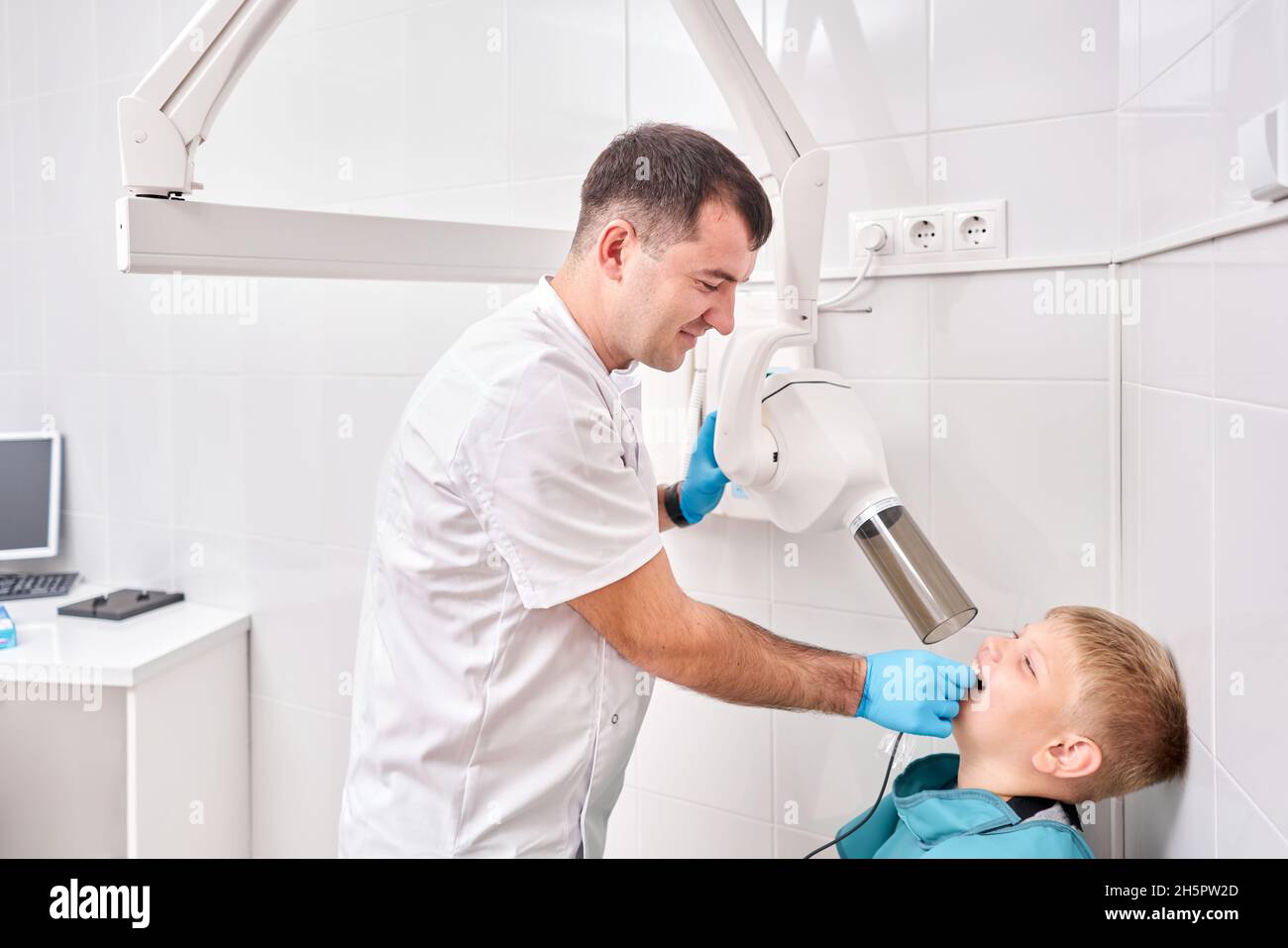 Radiographer taking teeth radiography to a boy using digital x-ray ...