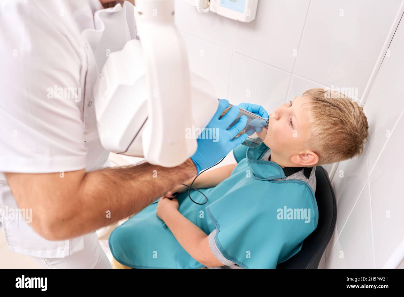 Radiographer taking teeth radiography to a boy using digital x-ray ...