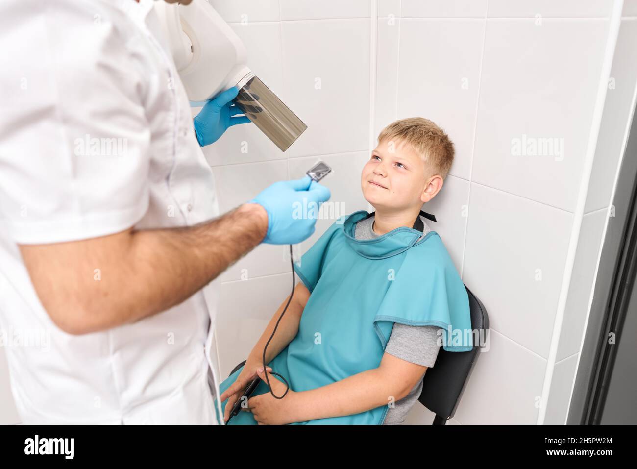 Radiographer taking teeth radiography to a boy using digital x-ray ...