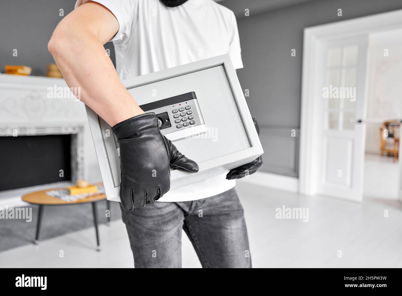 Thief with black mask stealing modern Metal safe with an electronic ...