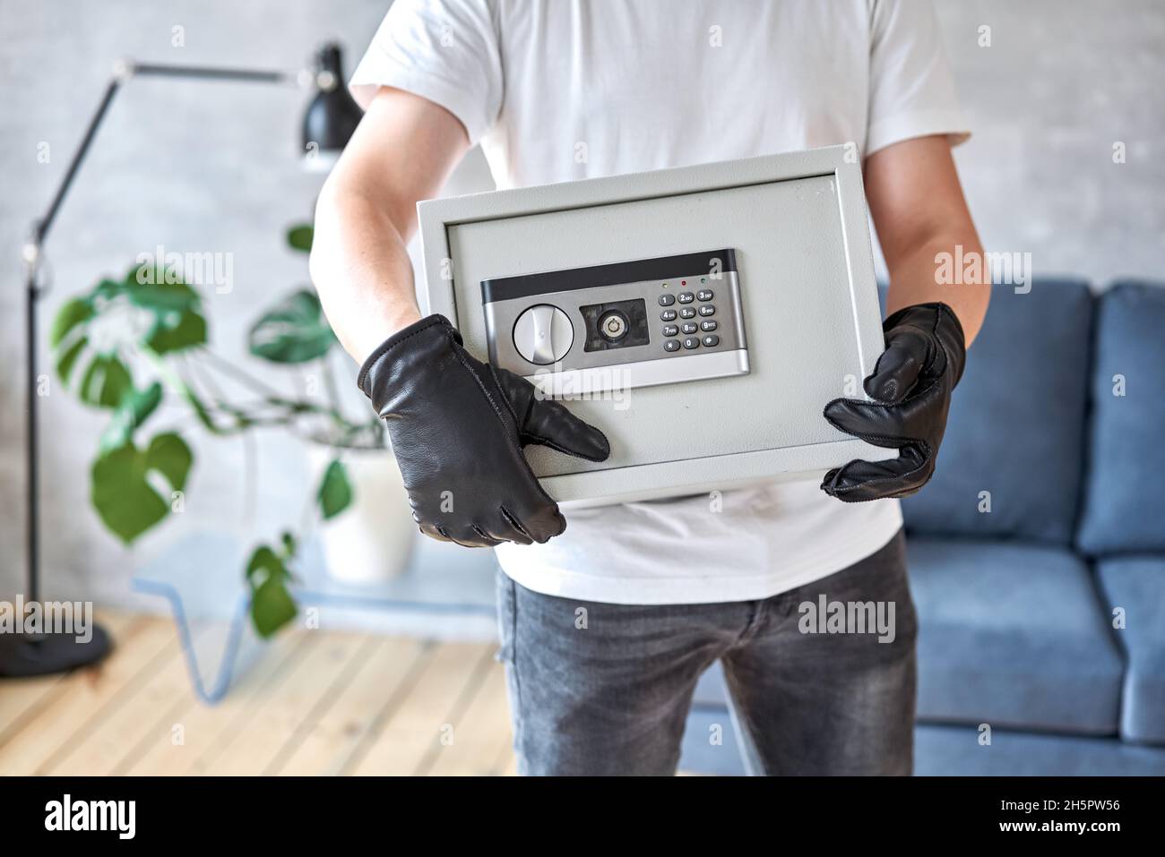 Thief with black mask stealing modern Metal safe with an electronic ...