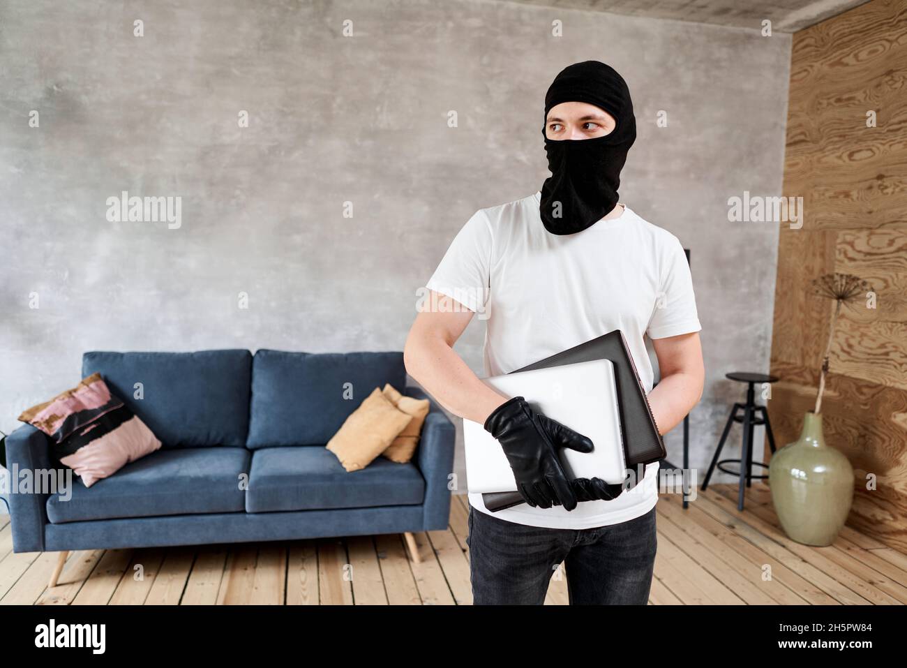 Thief with black balaclava stealing modern expensive television. Masked ...
