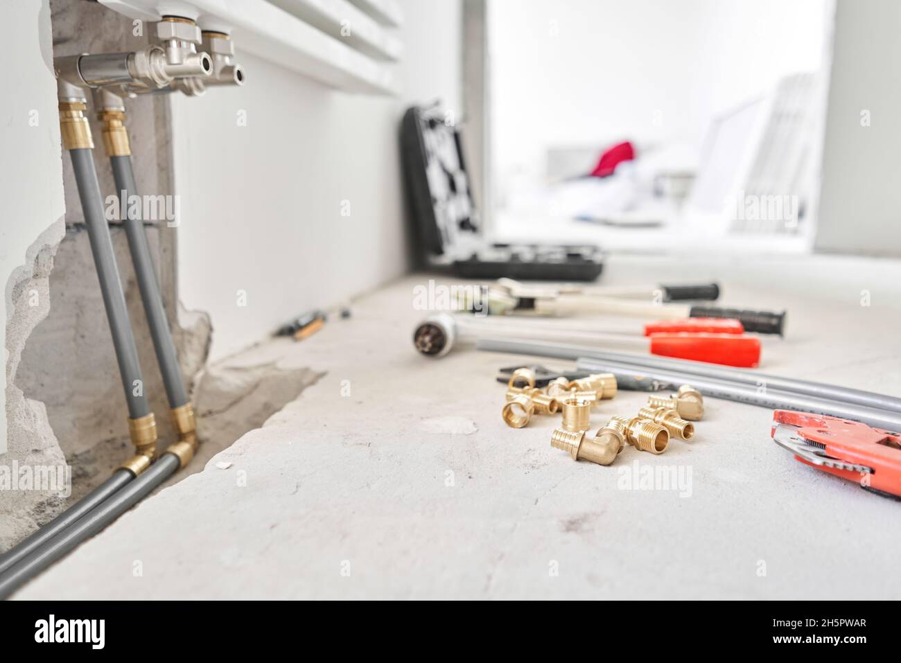 connection heating pipes to white Radiator in a new apartment under ...