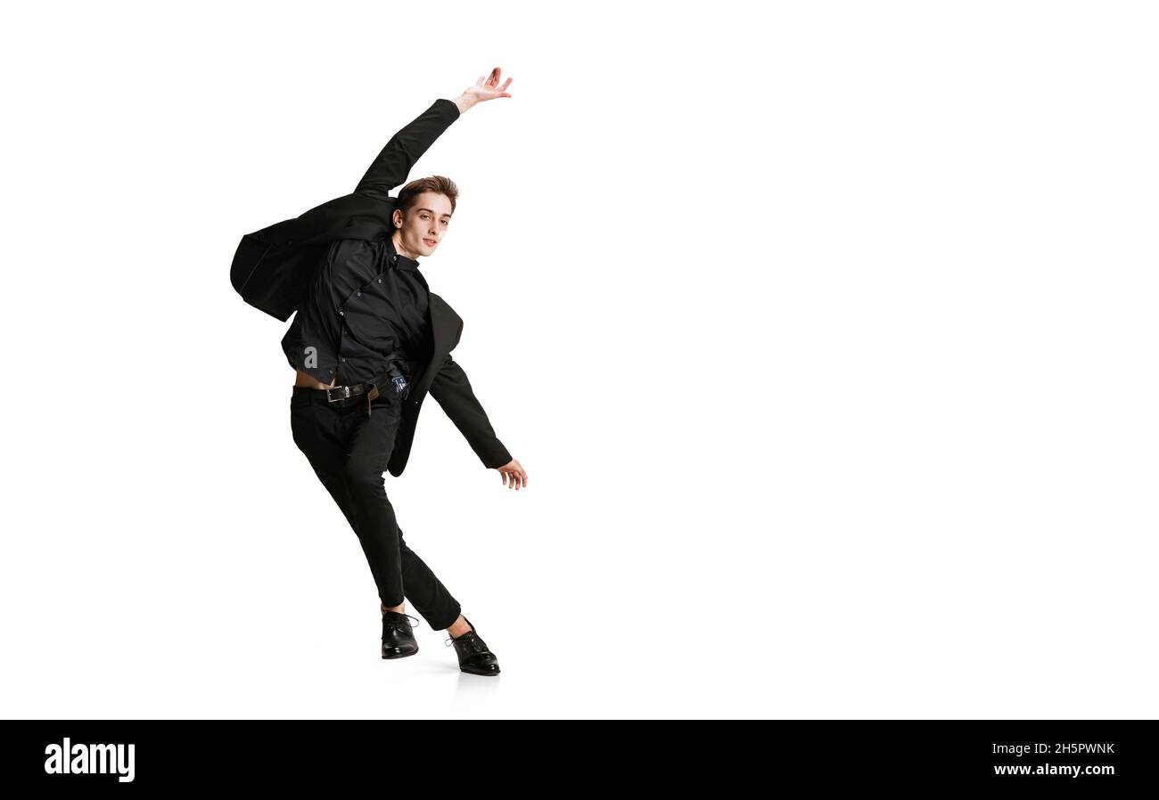 Young man in black business suit dancing isolated on white background ...