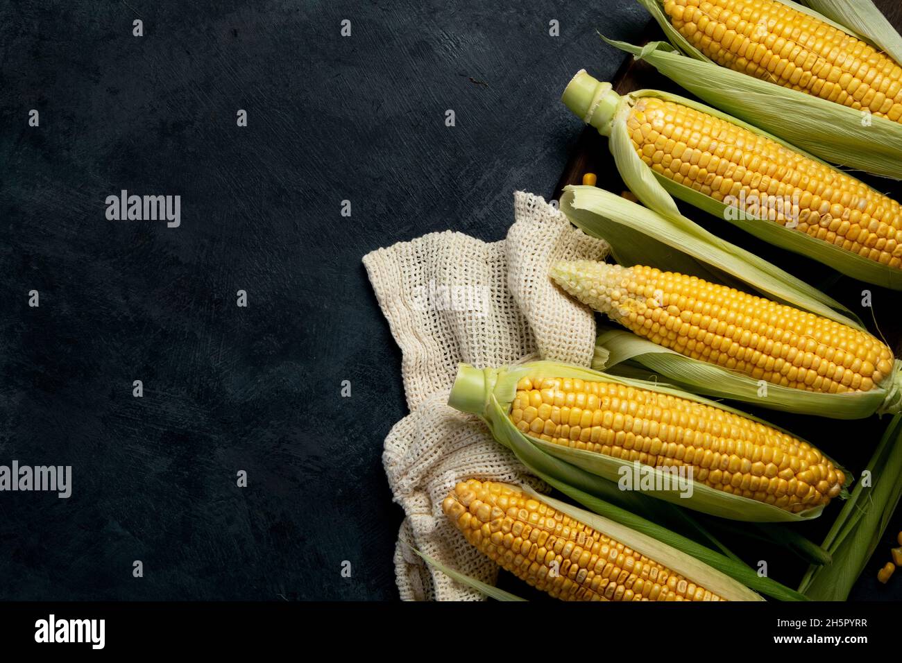 Raw corn or maize on dark background. Harvest food concept. Top view ...
