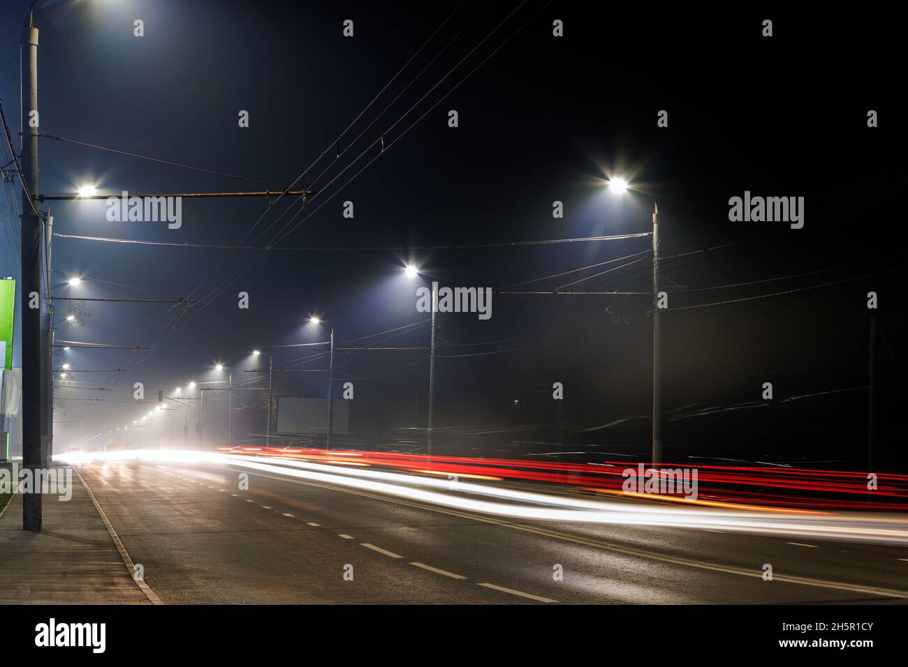 empty foggy night road with rows of lamp posts Stock Photo - Alamy