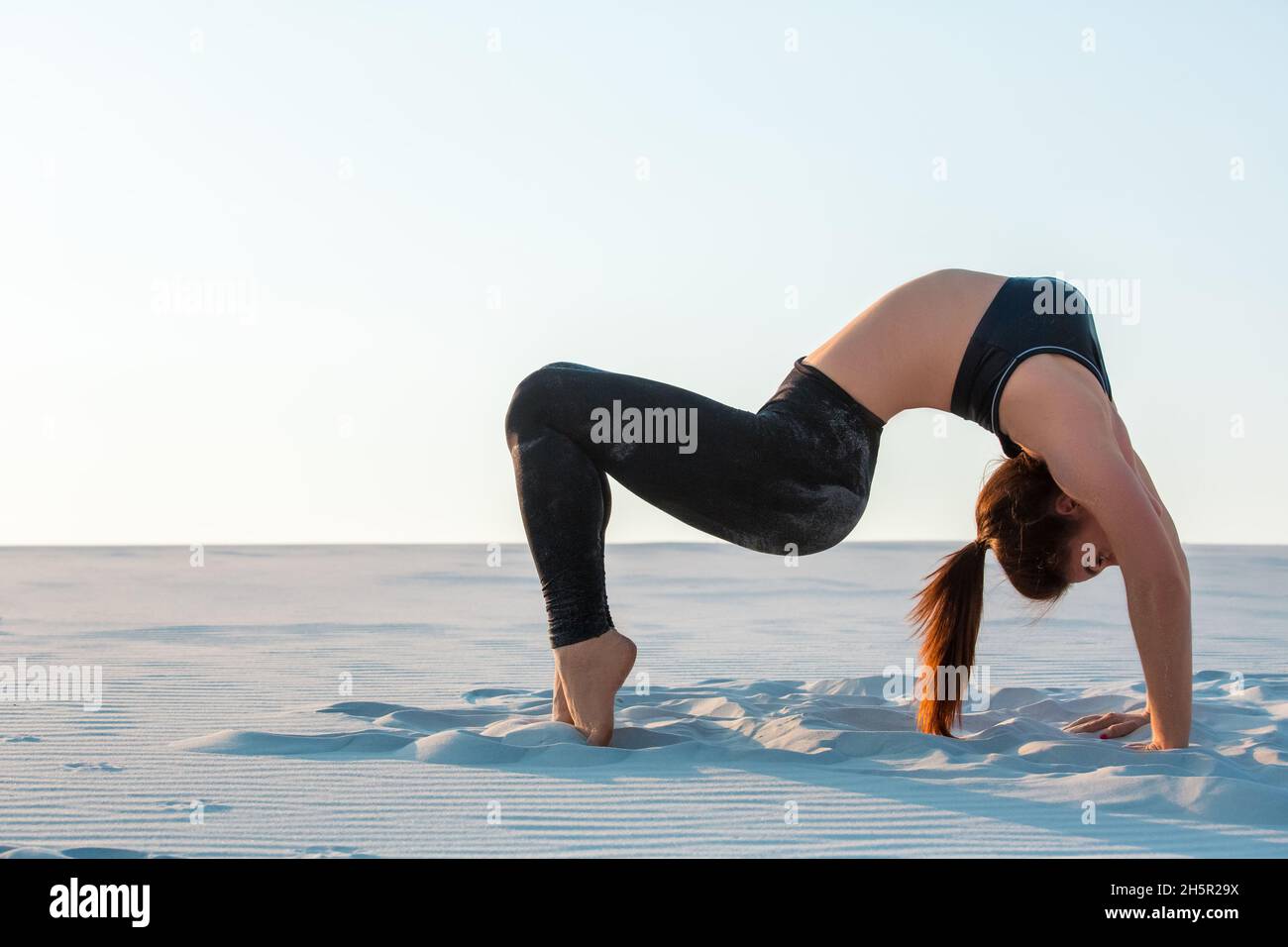 Fitness yoga woman stretching on sand. Fit female athlete doing yoga ...