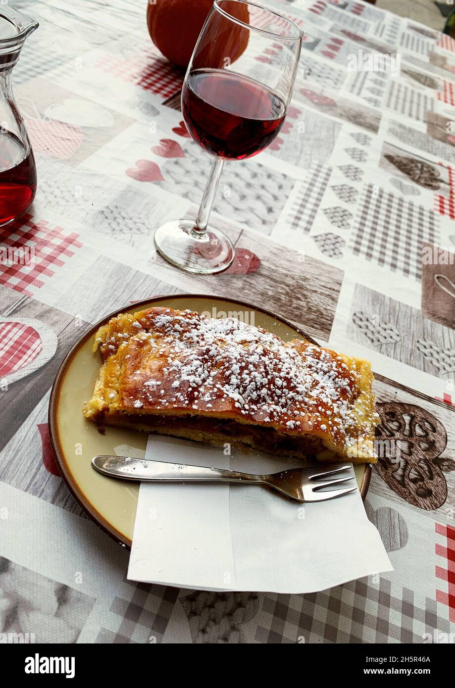 Apple strudel and red wine on a set table Stock Photo - Alamy
