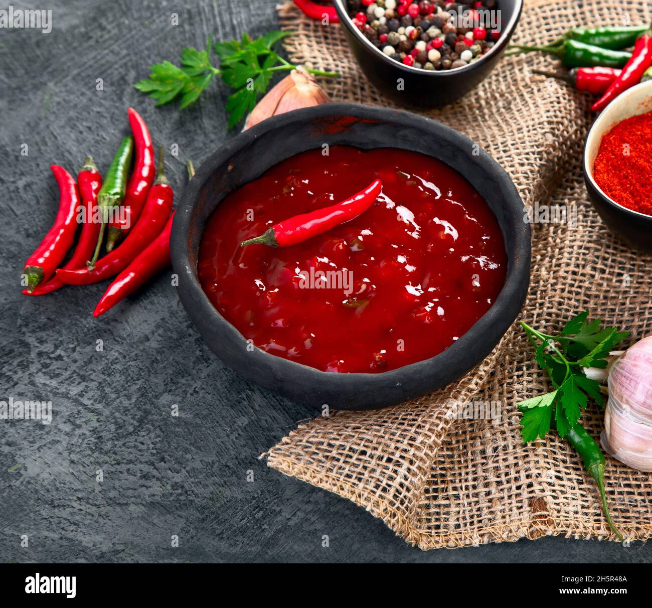 Spicy hot chilli tomato sauce on gray background. Traditional hot sauce ...