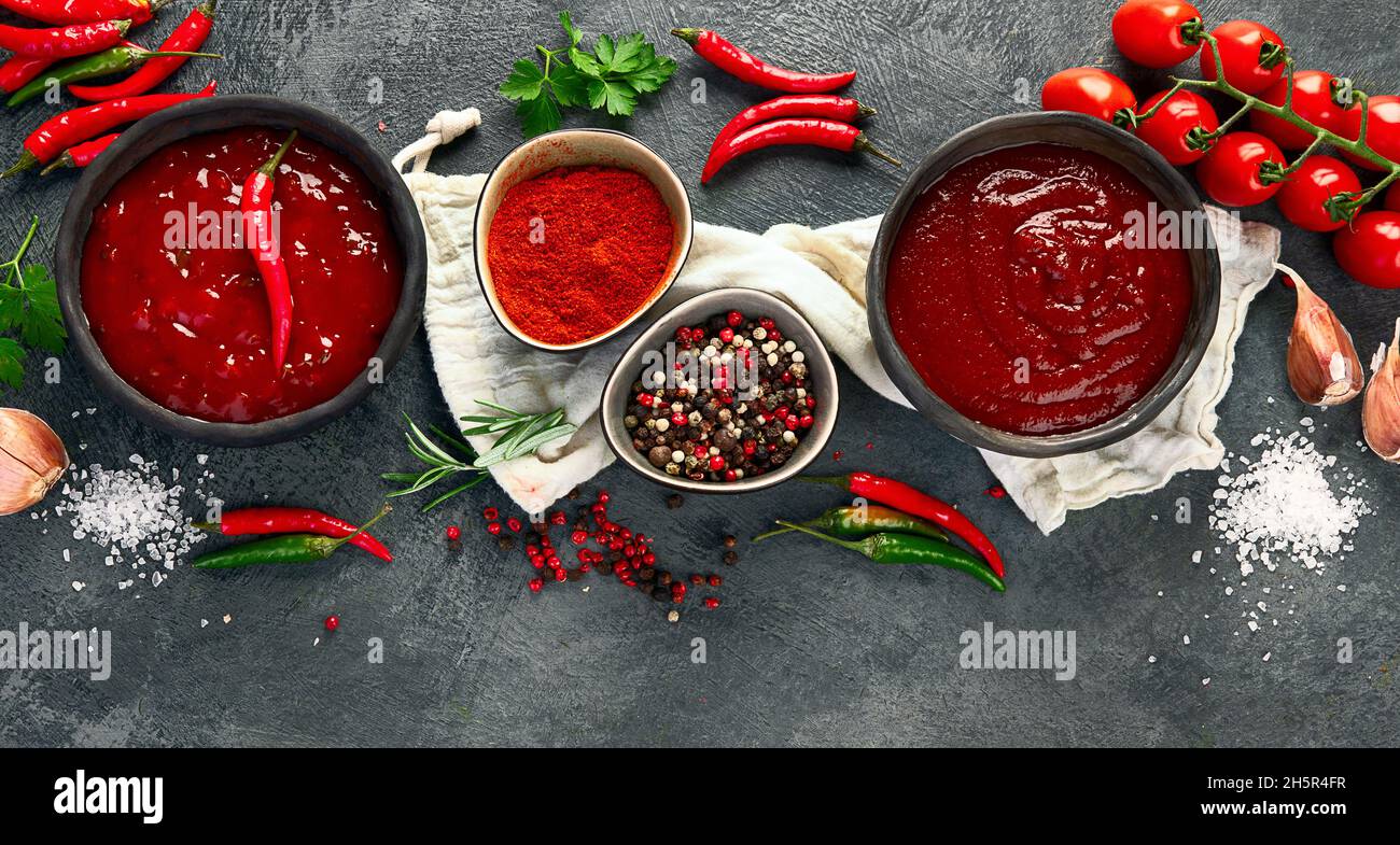 Spicy hot chilli tomato sauce on gray background. Traditional hot sauce ...