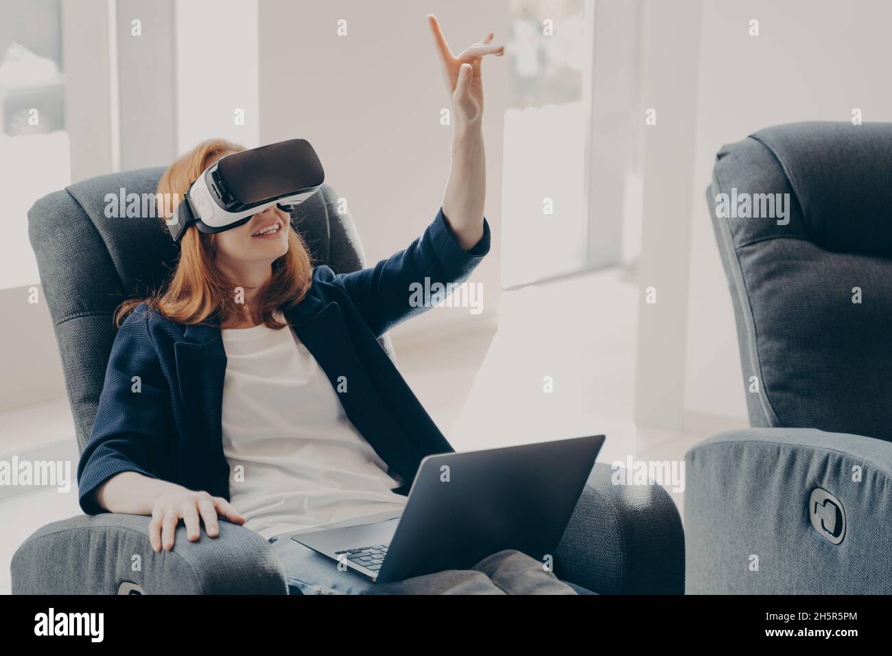 Female in VR headset pointing with finger, touching 3d object while ...