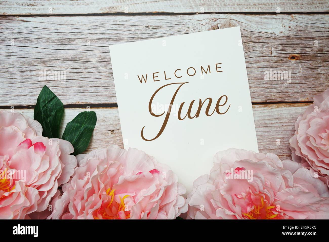 Welcome June card typography text with flower bouquet on wooden ...
