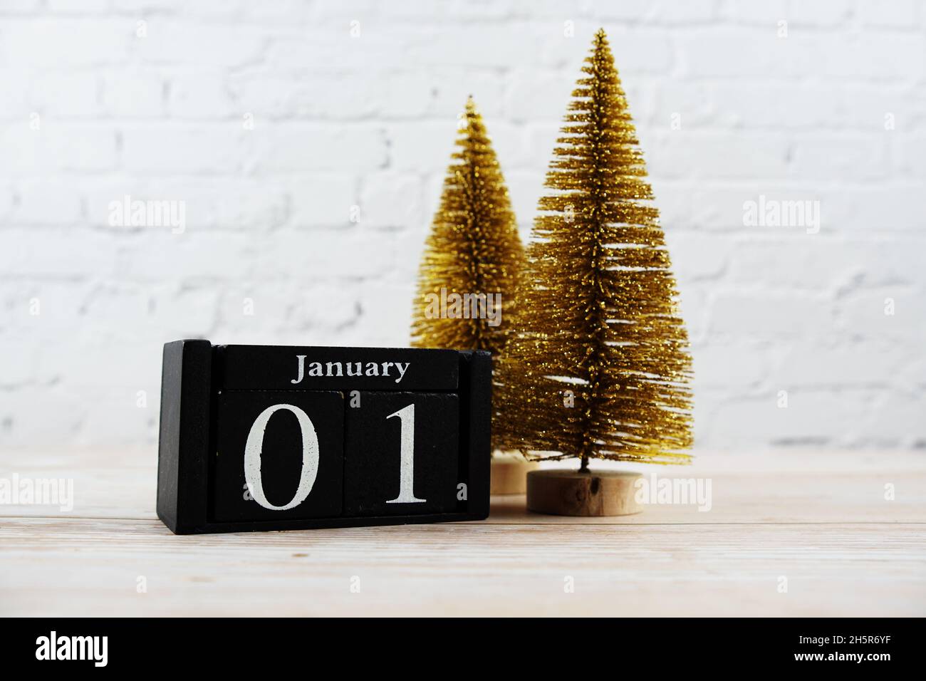 January 1st on the wooden calendar with little christmas tree on white ...
