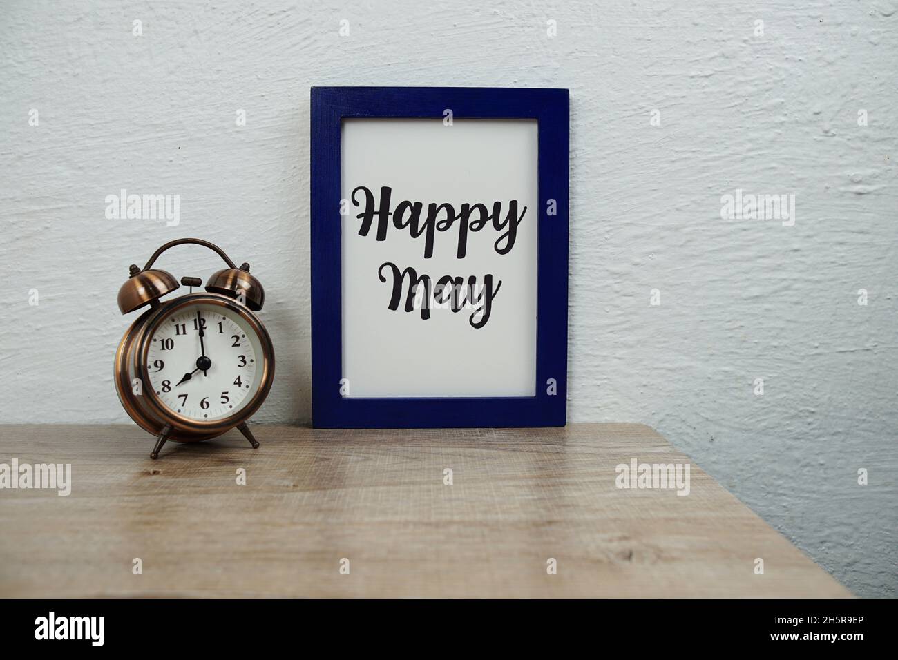 Happy May typography text with alarm clock and artificial plant ...