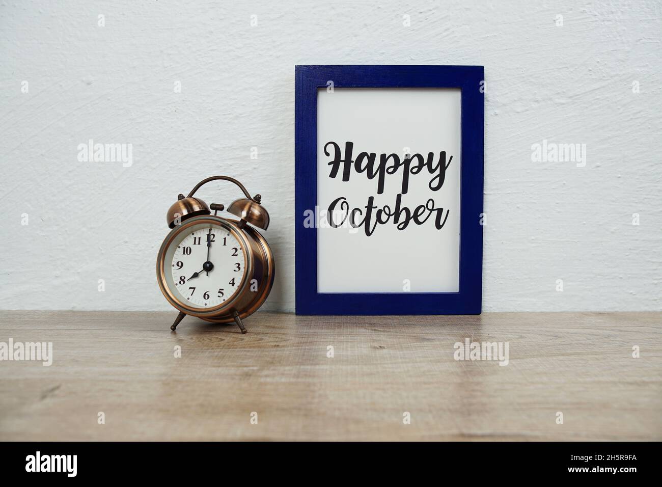 Happy October typography text with alarm clock on wooden table and ...