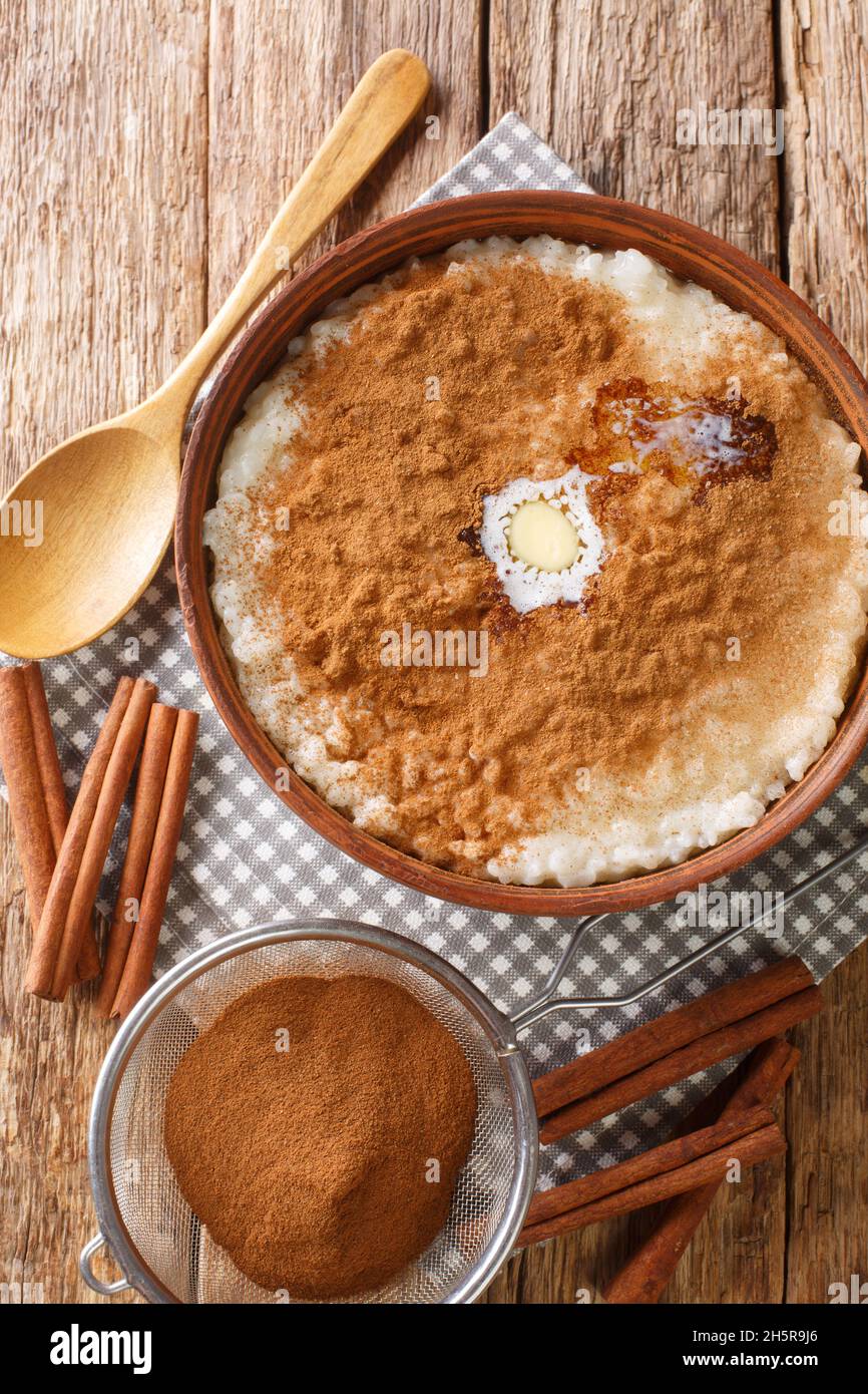 Rice pudding topped with cinnamon, sugar and butter closeup in a bowl ...