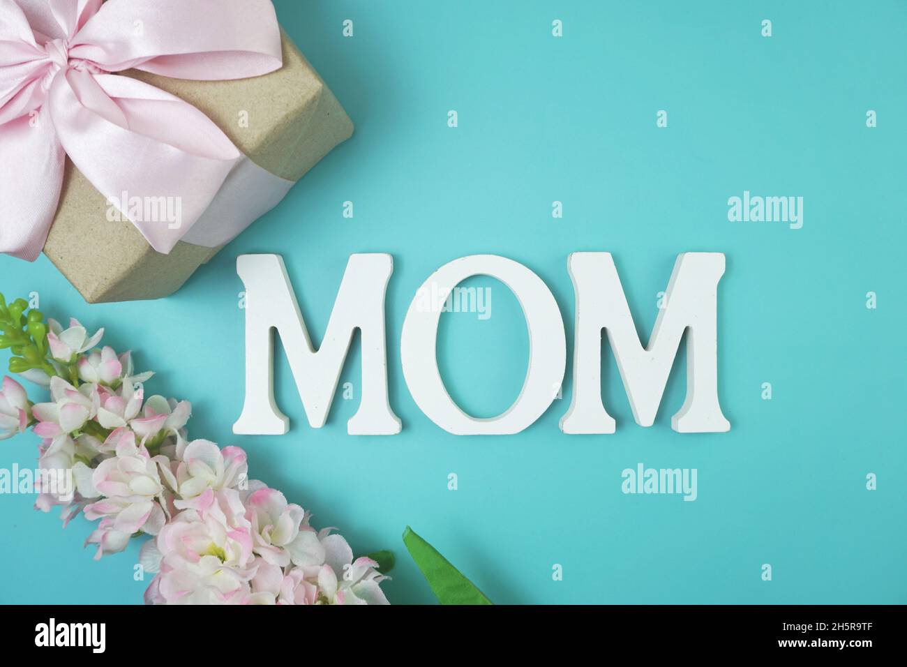 MOM alphabet letter with red flower and gift present on blue background ...