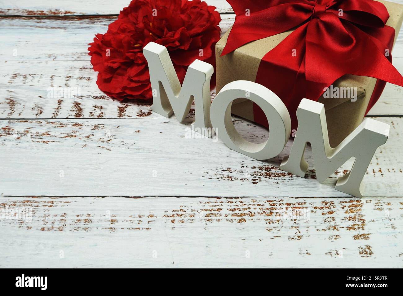MOM alphabet letter with red flower and gift present on wooden ...