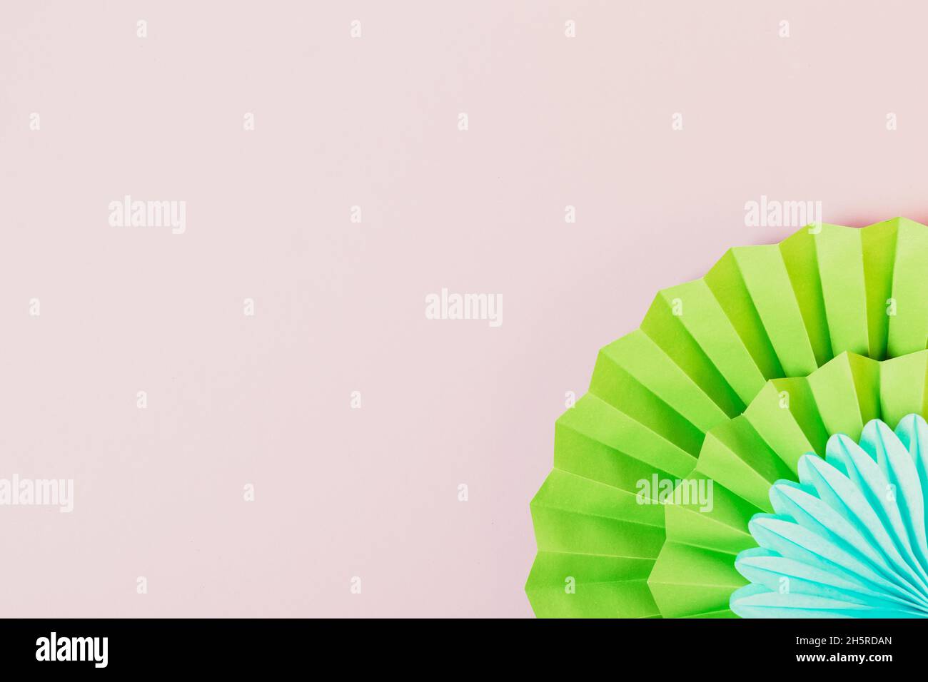 Holiday background with paper decorations. Green and blue origami fans ...