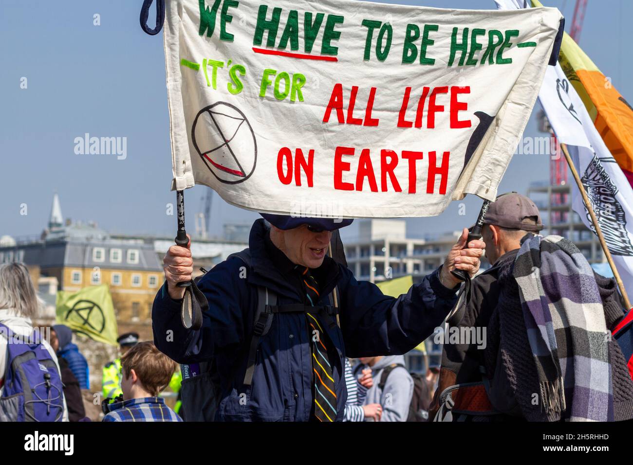 Street photograph of a man holding a banner at a climate change ...