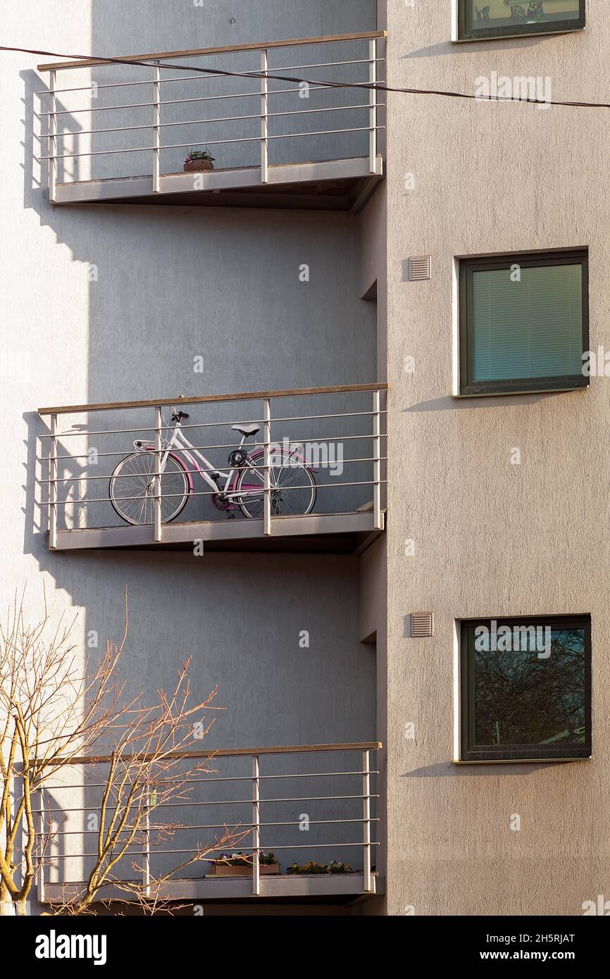 Three balconies on the wall of a concrete building. Someone is keeping ...