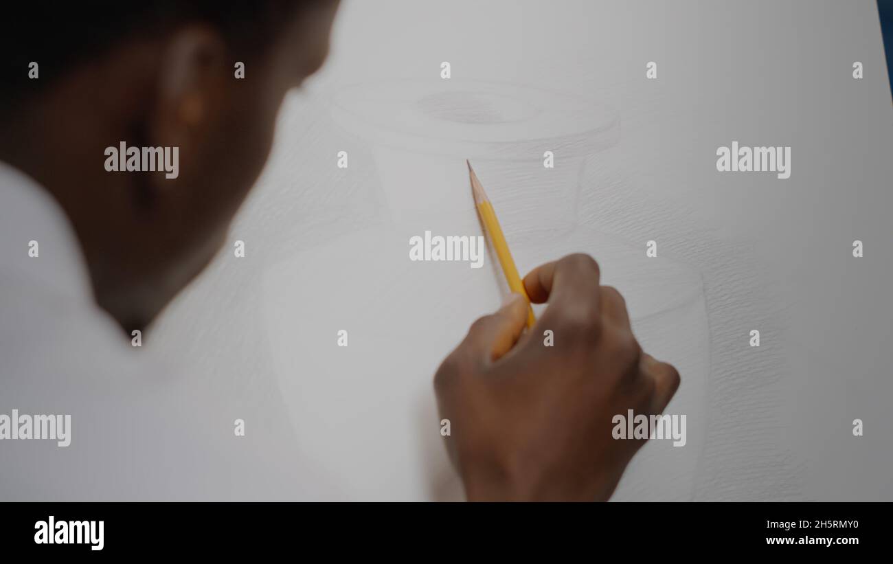 Close up of black hand drawing with art pencil on white canvas at ...